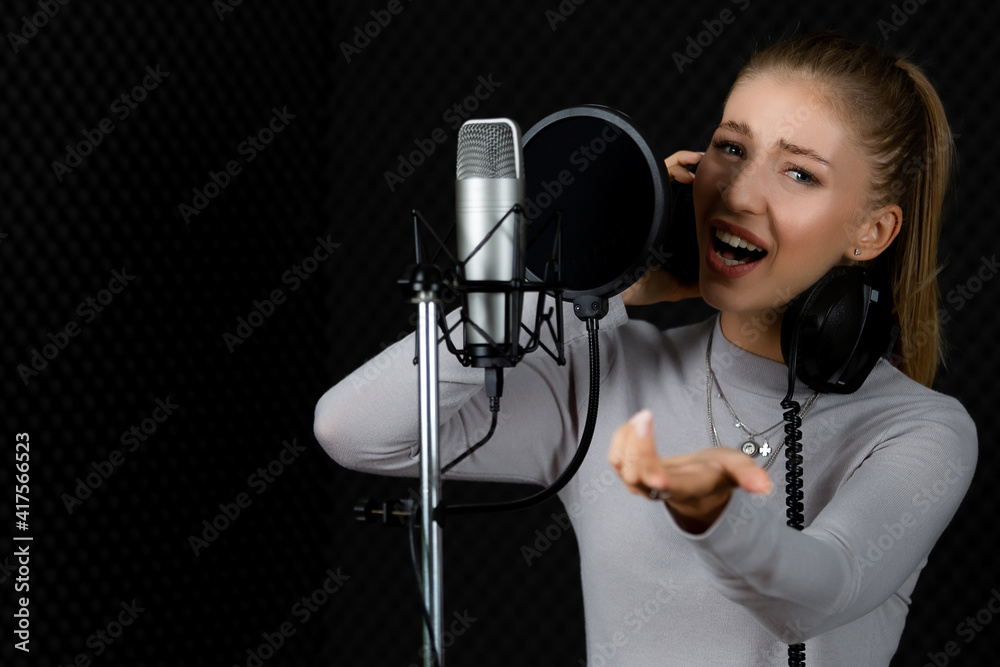 Teen female singer woking in voice studio with intention and happiness ...