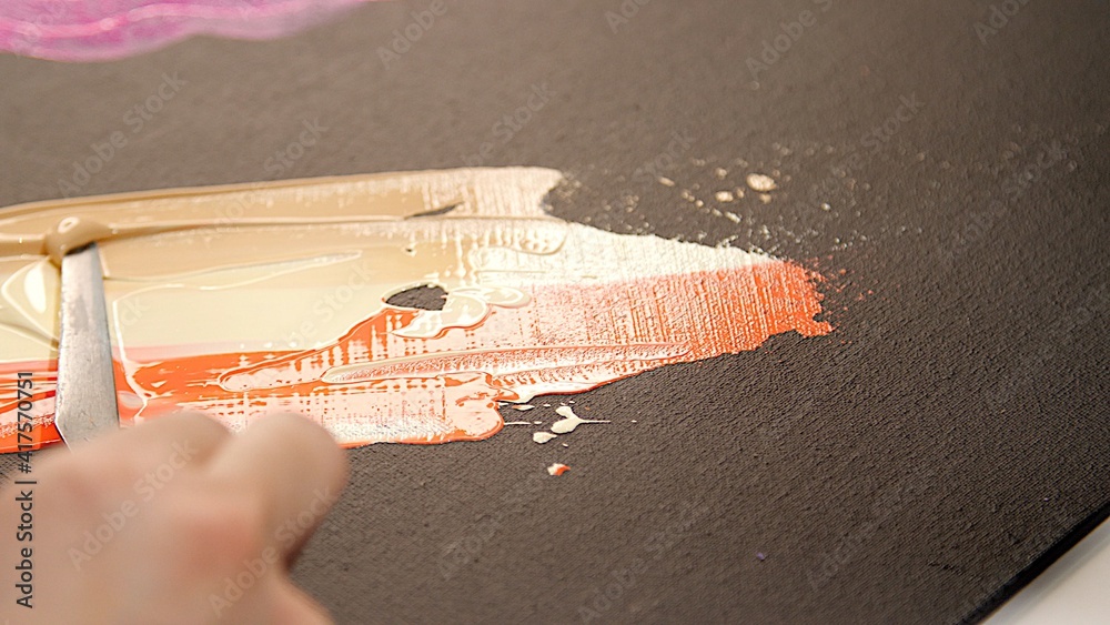Artist's hand draws with a palette knife. Process of acrylic drawing ...