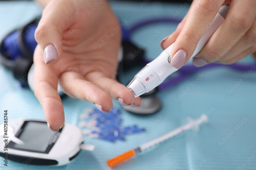 Woman drawing blood with lancet at home closeup. Blood glucose control ...