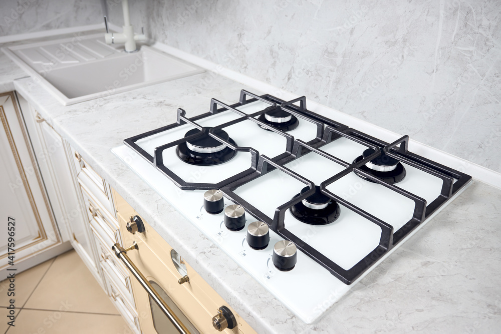 Modern white gas stove on counter top closeup. Hob gas stove made of ...