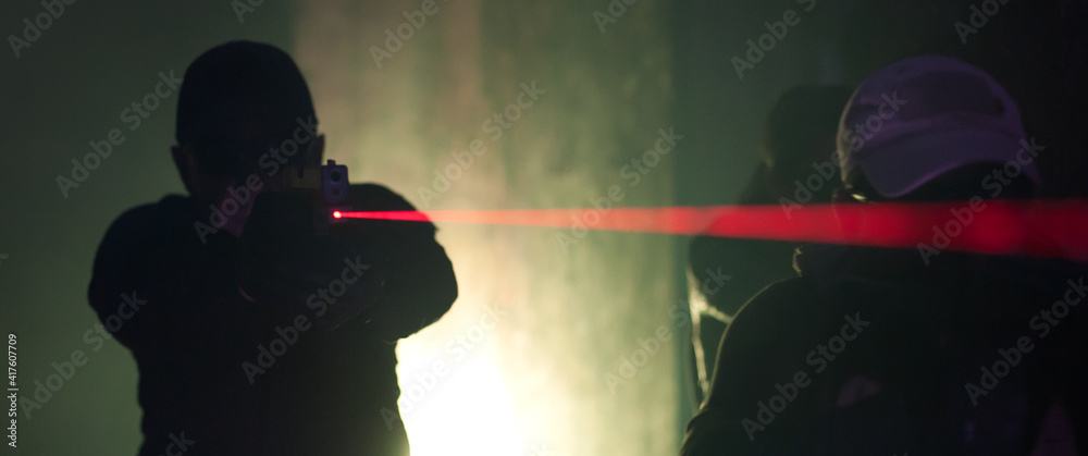 Army soldier in action aiming at weapon laser sight optics. Shooting ...