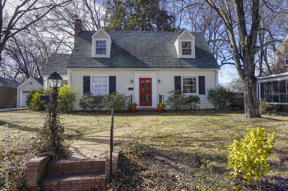 Street view of a mid-century modern, cape cod style house in a suburban ...
