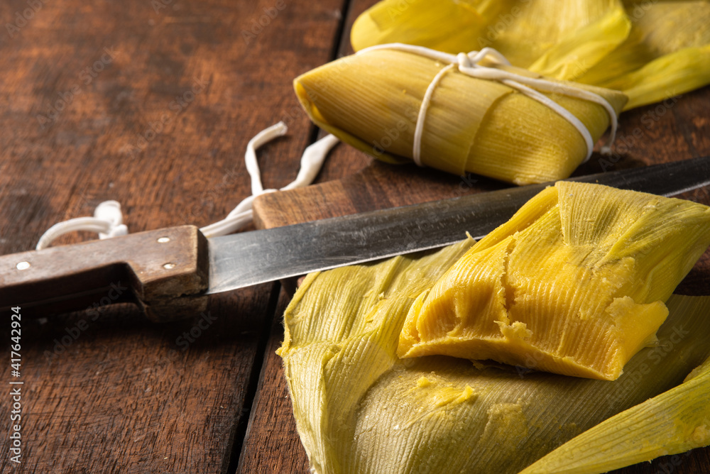 Pamonha, Brazilian corn food, called pamonha. On a rustic table with ...
