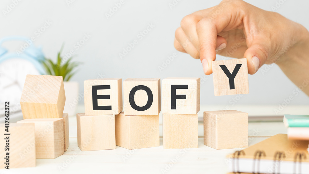 EOFY, End of Financial Year text. wood cubes and white background Stock ...