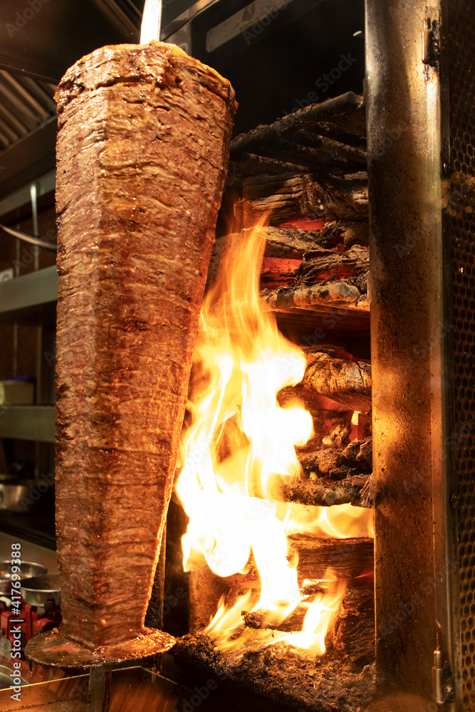 Shawarma is prepared on fire from firewood. Street food restaurant ...
