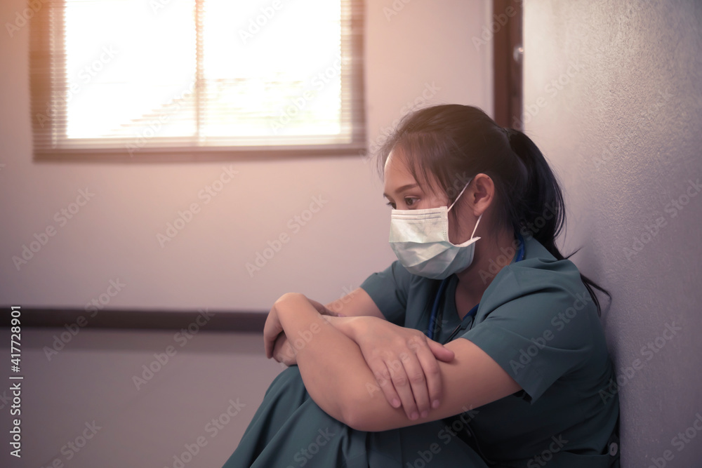 Asian female healthcare worker doctor nurse wearing surgical mask, sad ...