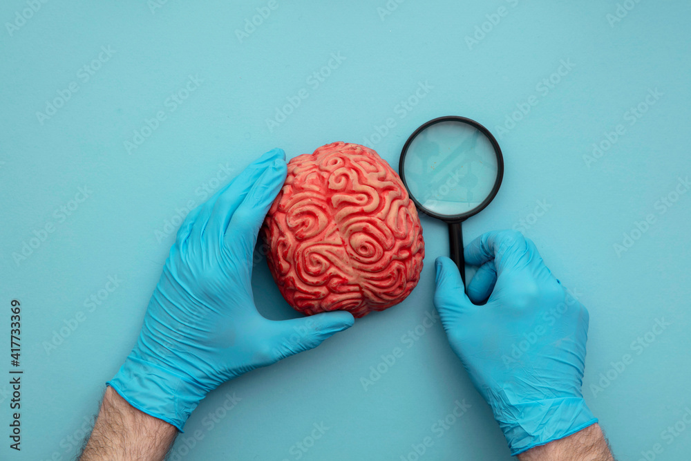 Doctor using a magnifying glass to look at a brain. Mental health ...
