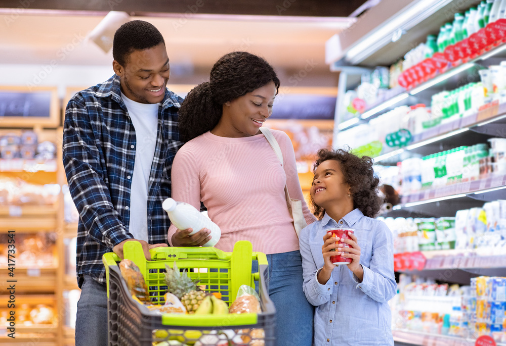 Foto de Family shopping concept. Young black parents with pretty ...