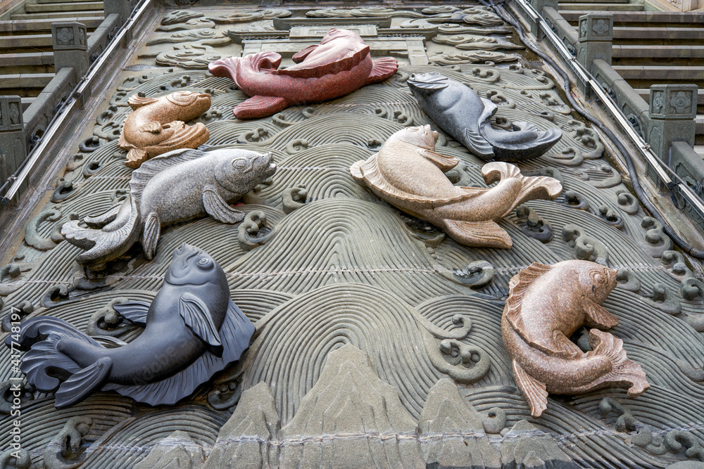 Stone carving of carp playing in water in traditional Chinese culture ...