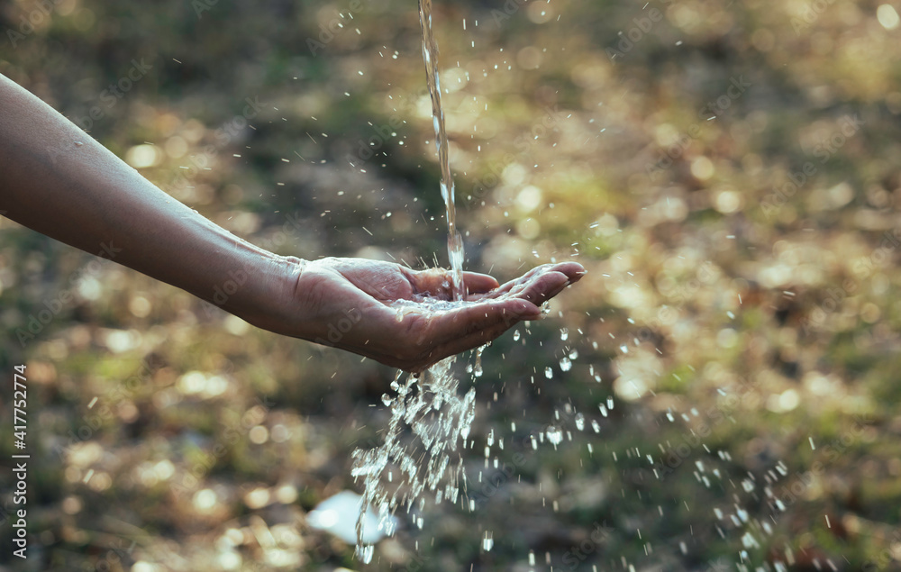 Water flow to hand in the garden on nature background. Stock Photo ...