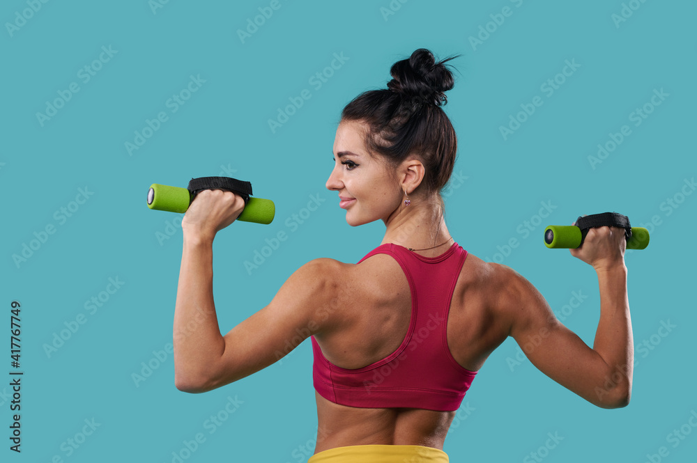 Attractive and muscular build young woman demonstrates back muscles ...