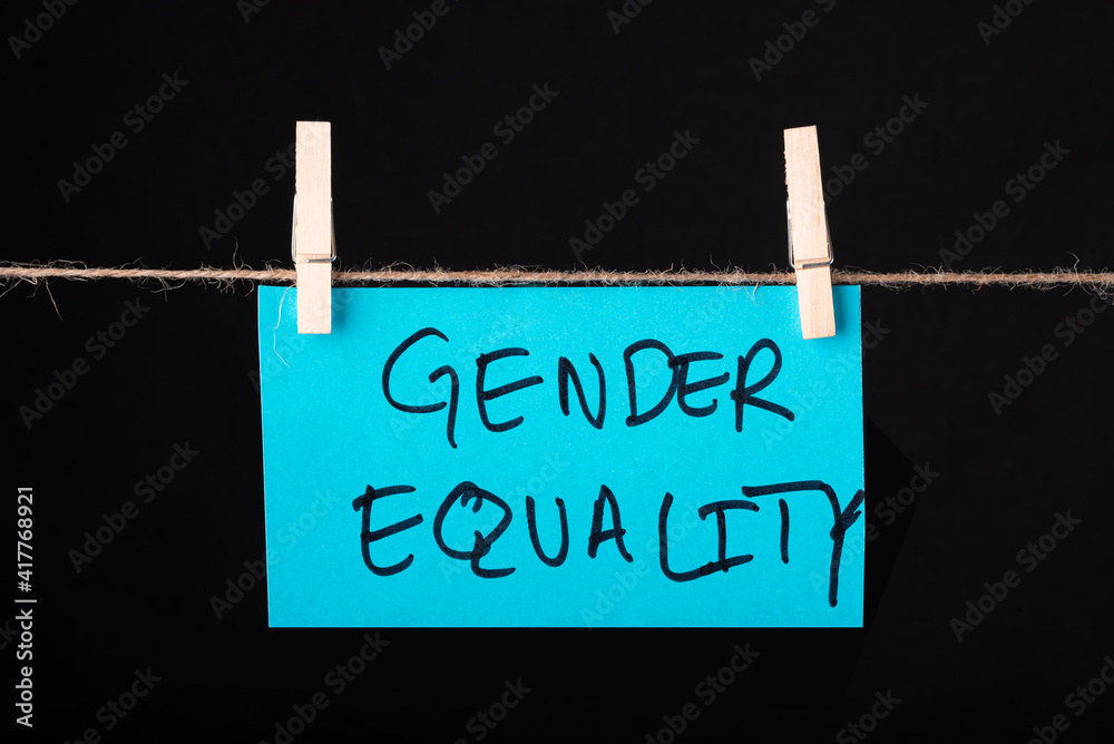 Gender Equality word written on a Blue color sticky note hanging with a ...