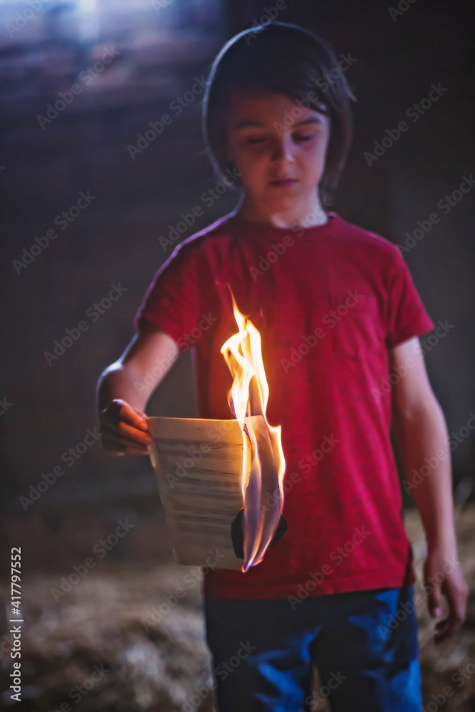 Preteen child, burning paper in the attic Stock Photo | Adobe Stock