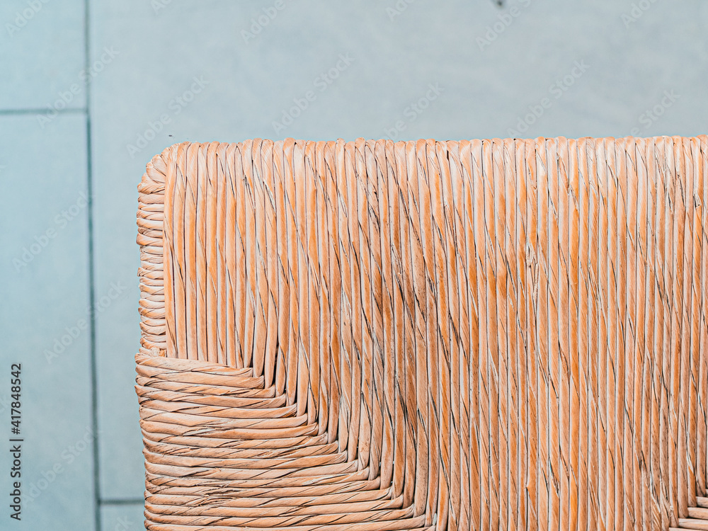 Corner of square seat of a wicker chair with a geometric pattern ...