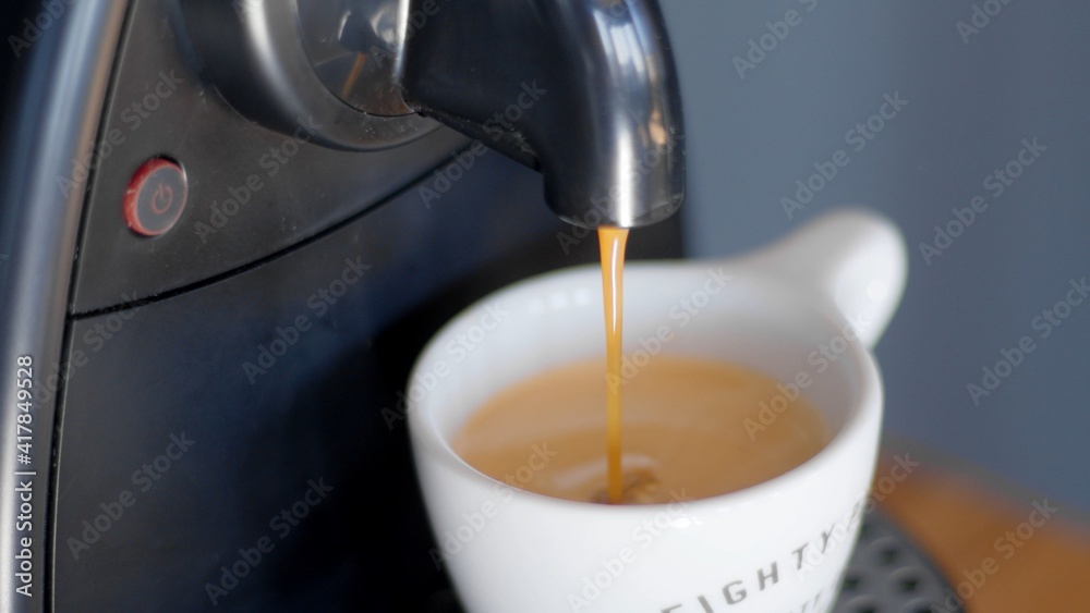 Closeup making coffee from a capsule in an automated Nespresso machine ...