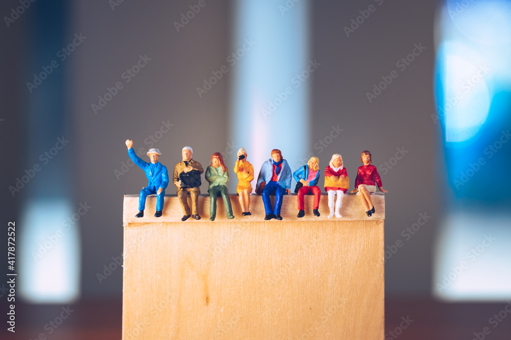 Miniature people, man and woman sitting together on blurry background ...