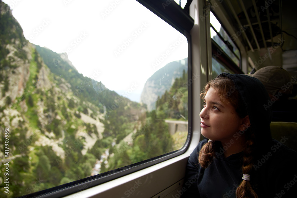 Teenage girl looking smiling out of a train window Stock Photo | Adobe ...