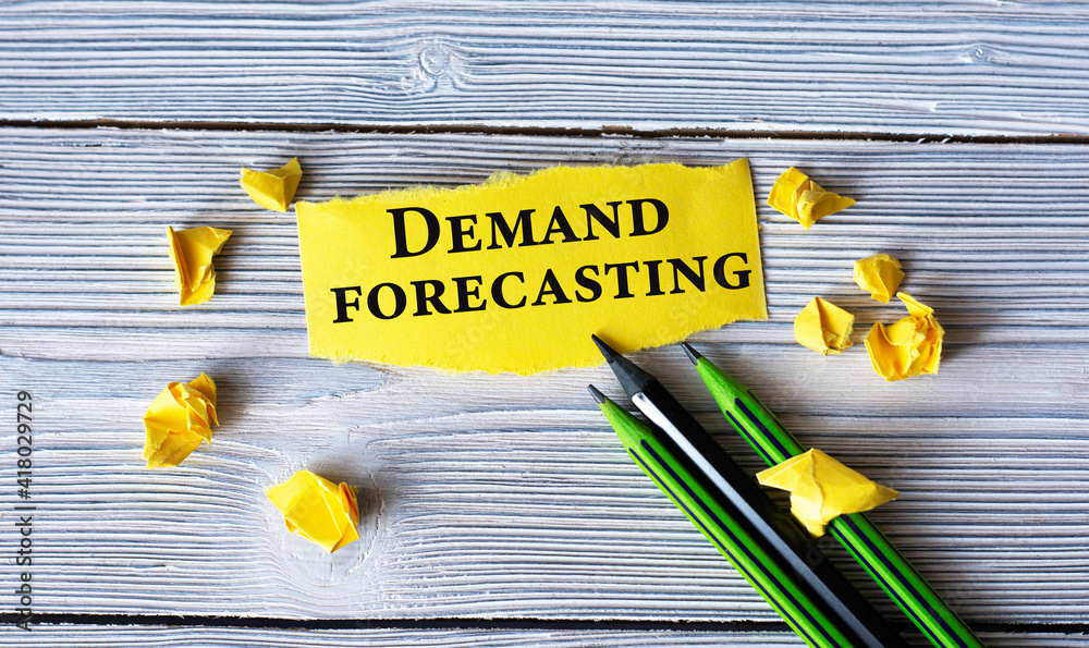DEMAND FORECASTING - word on a yellow tattered piece of paper with ...