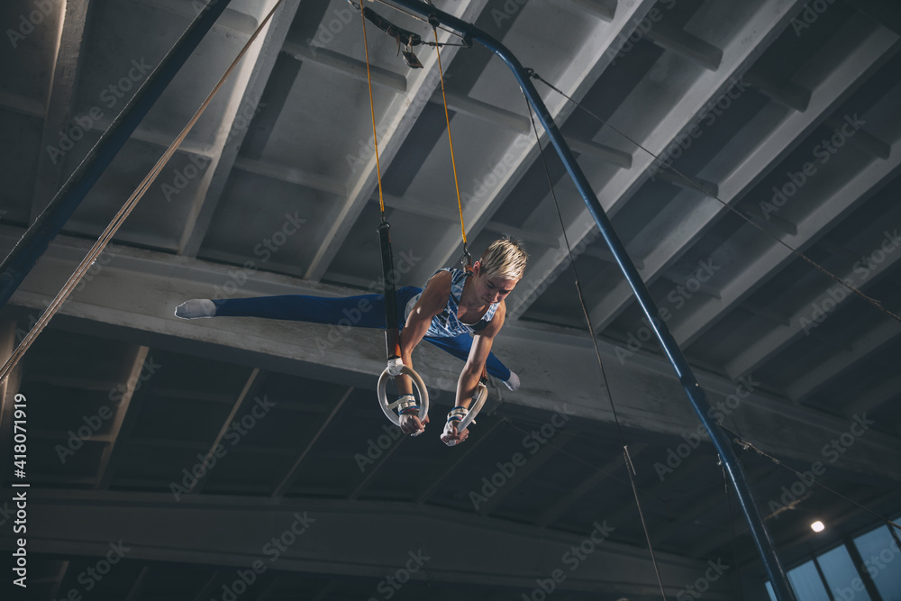 Flying. Little male gymnast training in gym, composed and active ...