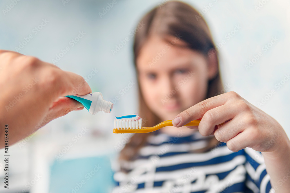 dental hygiene. parents the father squeezes out a colorful toothpaste ...