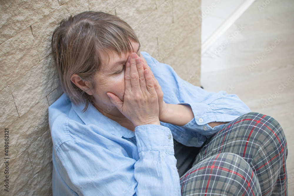Stress Senior woman sitting on the floor with his face in his hands ...