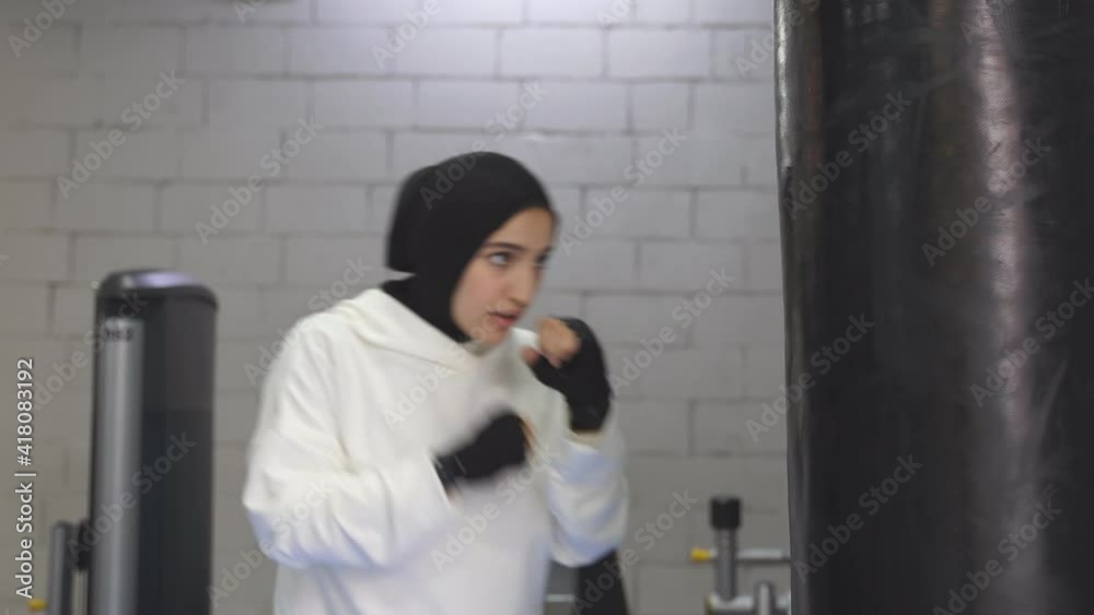 Video Stock Muslim female boxer in a sports hijab is engaged in boxing ...