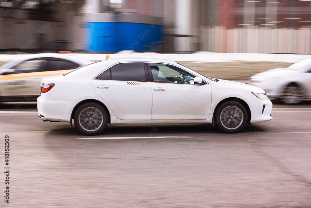 White Taxi car on the street in motion. Side view of Toyota Camry rides ...