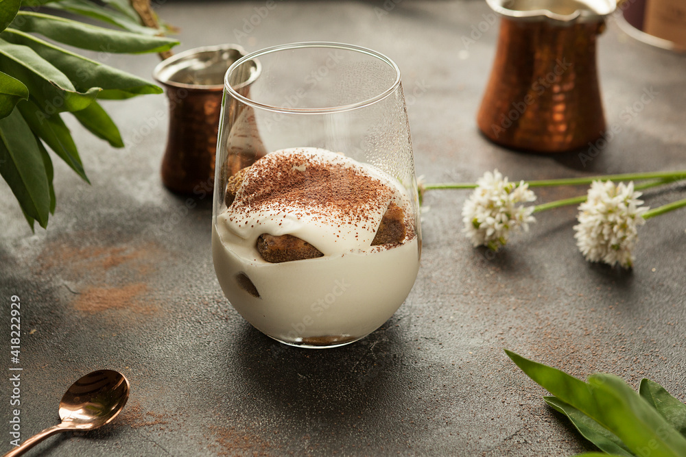 beautiful white cream dessert in a transparent glass. tiramisu in a ...