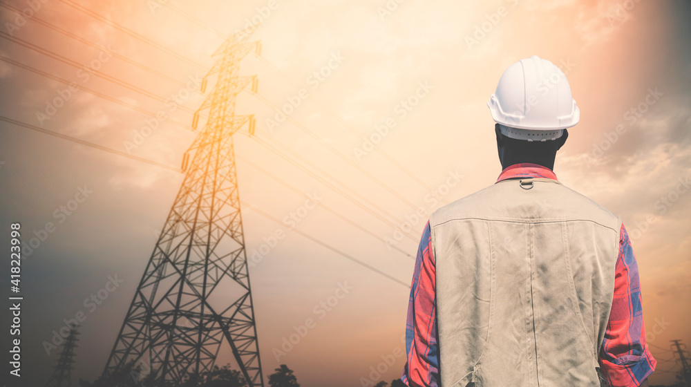 Electrical engineer standing and looking with high voltage electricity ...