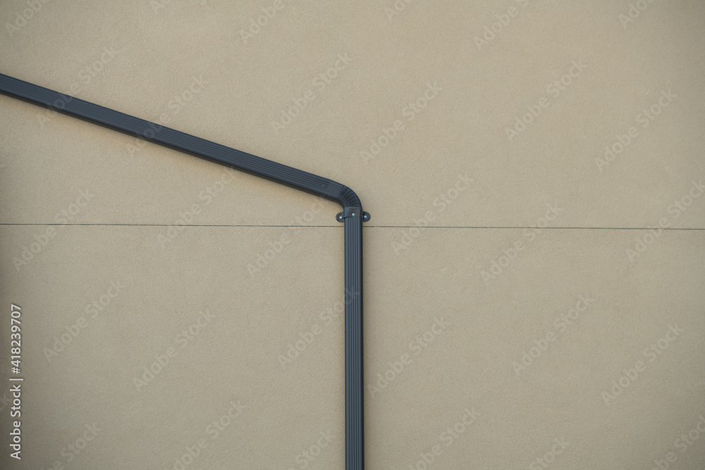 metal down spout or down spout attached to exterior concrete wall of ...