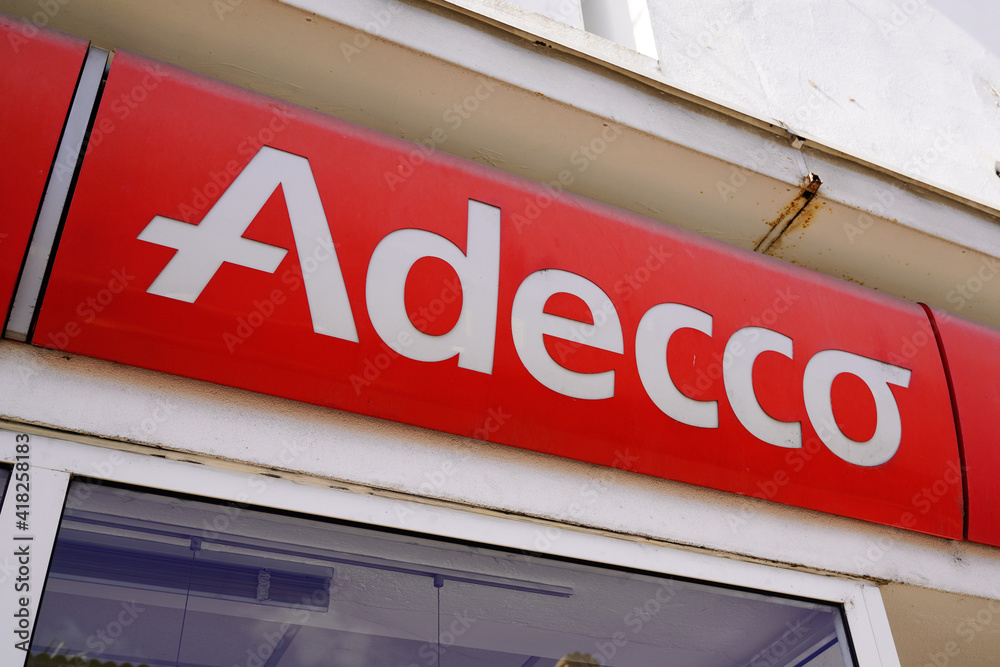 Adecco sign logo and text brand on wall building facade Temporary work ...