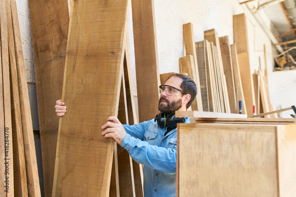 Carpenter with a solid wood board in the wood store Stock Photo | Adobe ...