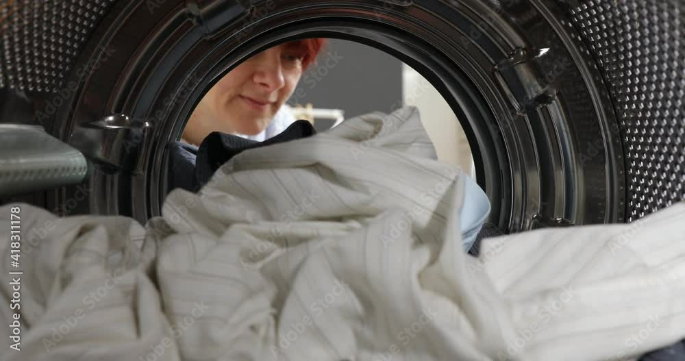 Stockvideo A broken washing machine. Women Housewife takes out laundry ...