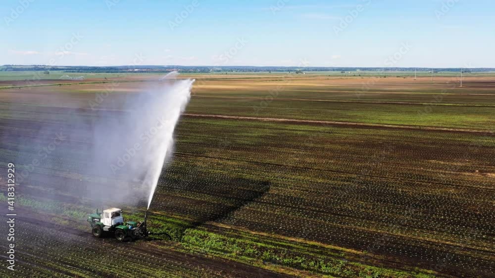 Irrigation of farmland with a tractor irrigation system from above. An ...