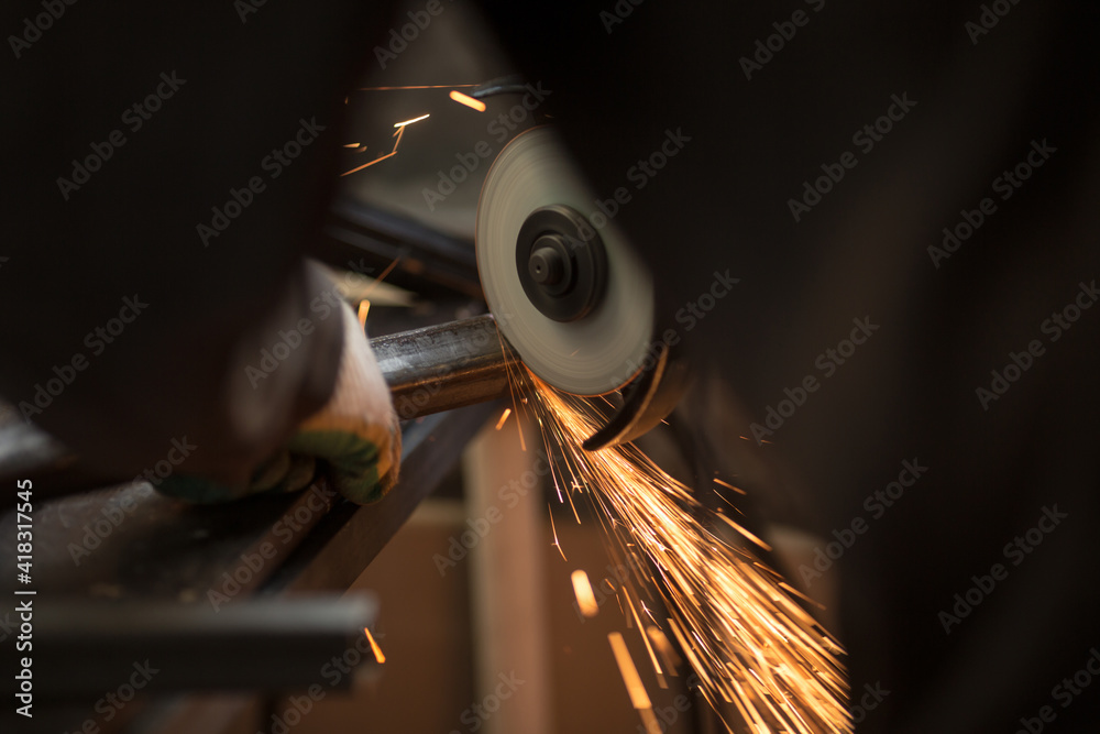 angle grinder a disc turns, a man with his hands cuts off a metal ...