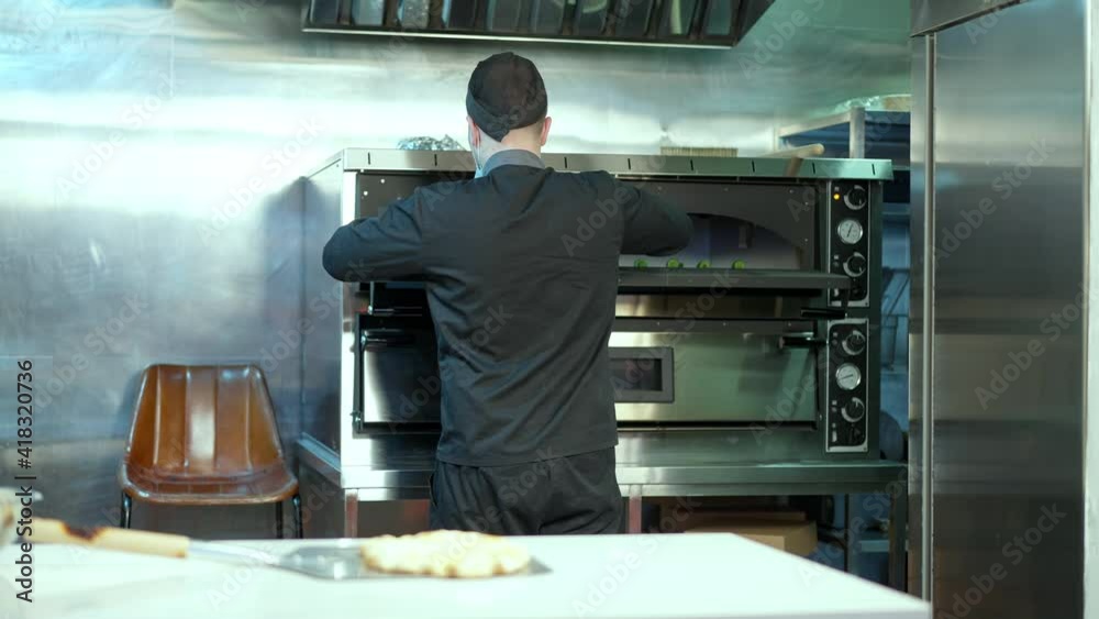 Caucasian cook working in restaurant kitchen on coronavirus pandemic ...