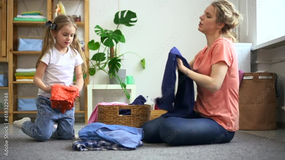 Mother and daughter doing household chores and talking, sitting in home ...