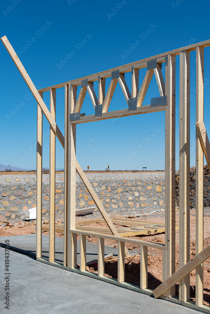 A prefab wall section is in place on a new home construction project ...