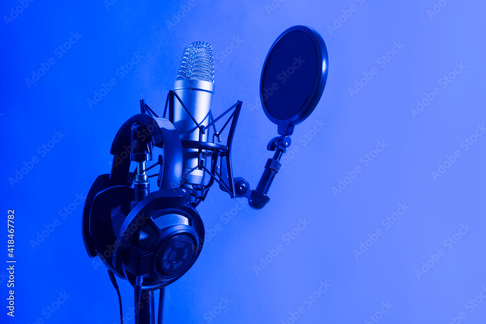 Professional microphone with waveform and headphones a on blue ...
