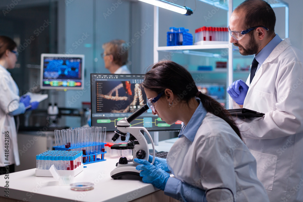 Team of medical research scientists analyzing virus disease using ...