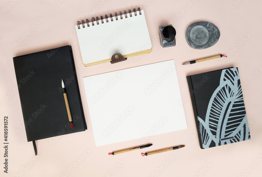 Blank sheet mockup, notepads and calligraphy brushes. Top view ...