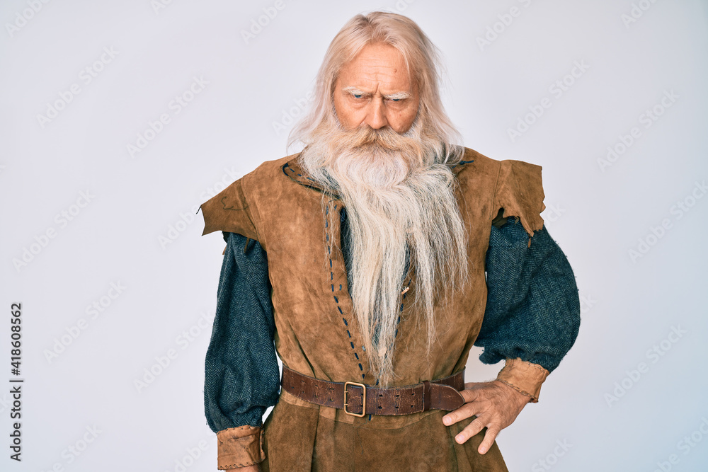 Old senior man with grey hair and long beard wearing viking traditional ...