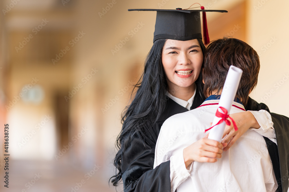 Happy student hugging her friend and celebrating her graduation Stock ...