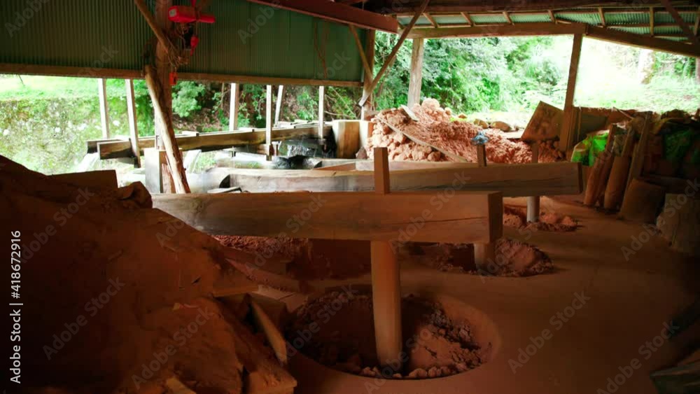 Three water hammers each smashing on clay in the process of making an ...