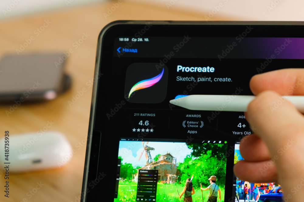 Procreate logo shown by apple pencil on the iPad Pro tablet screen. Man ...