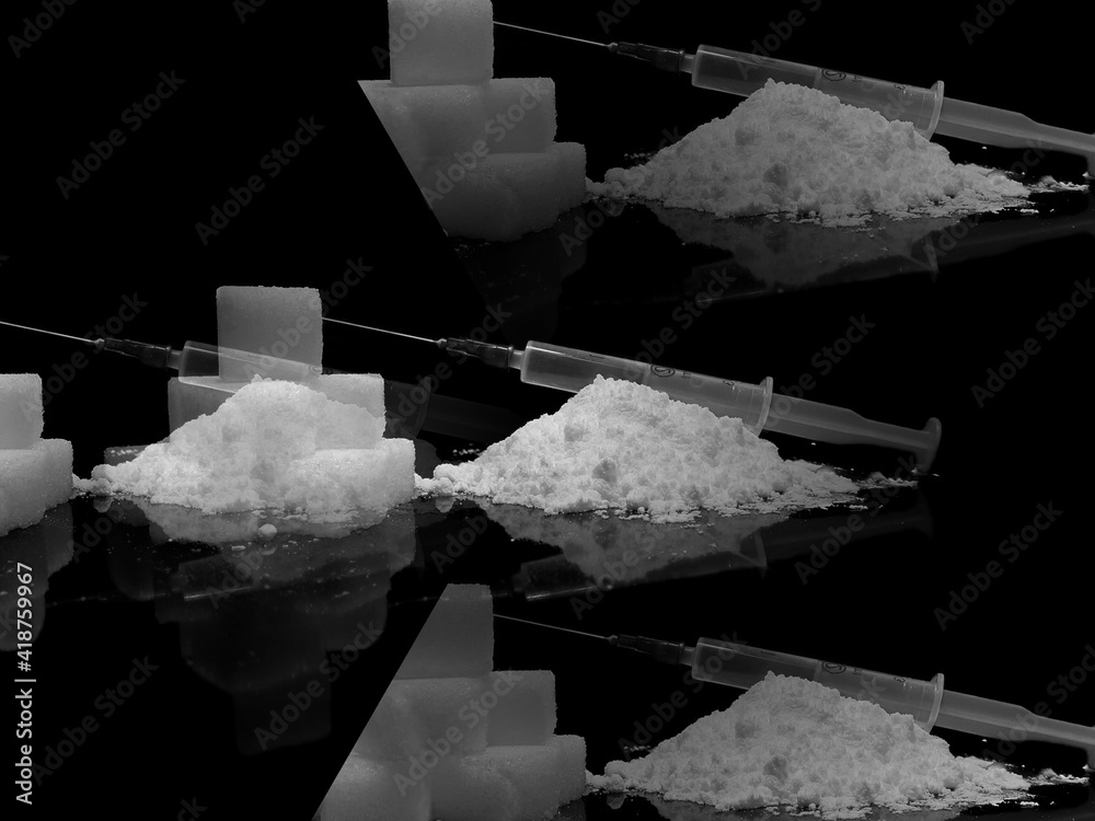 Injection syringe on cocaine drug powder pile and lump sugar cubes on ...