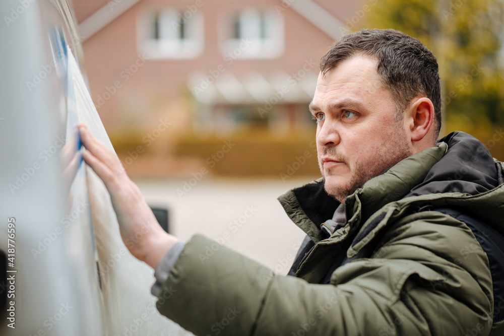 Attach a sticker to a car. You check whether a sticker sticks well to a ...