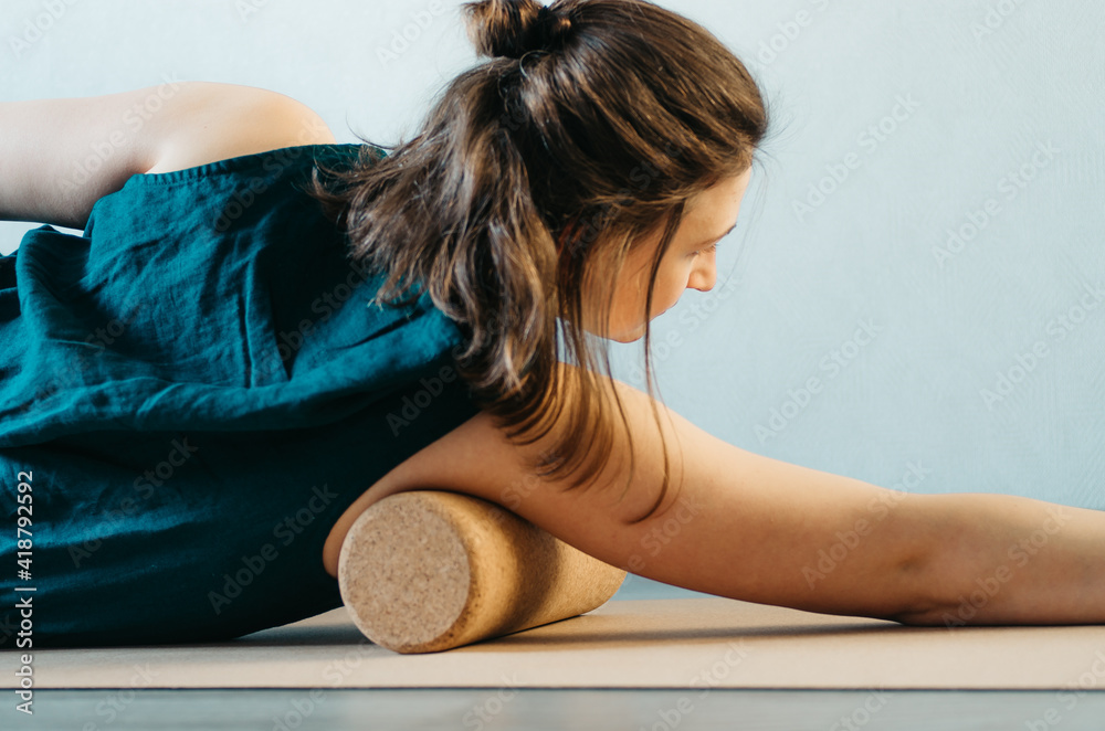 Upper body details of woman rolling lower armpit on a cork massage ...