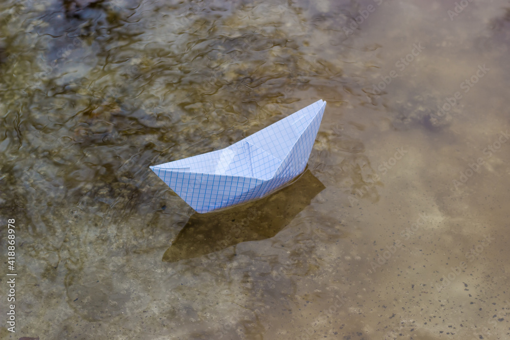 Paper boat in a puddle of water from melted snow Stock Photo | Adobe Stock