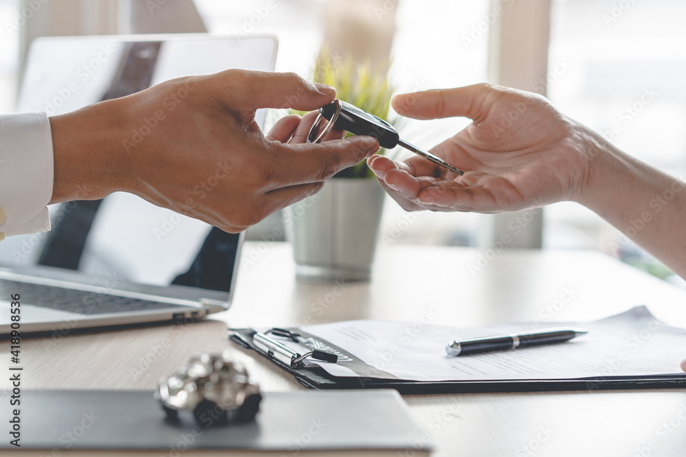Car rental service concept. Close up view Hand of agent giving car key ...